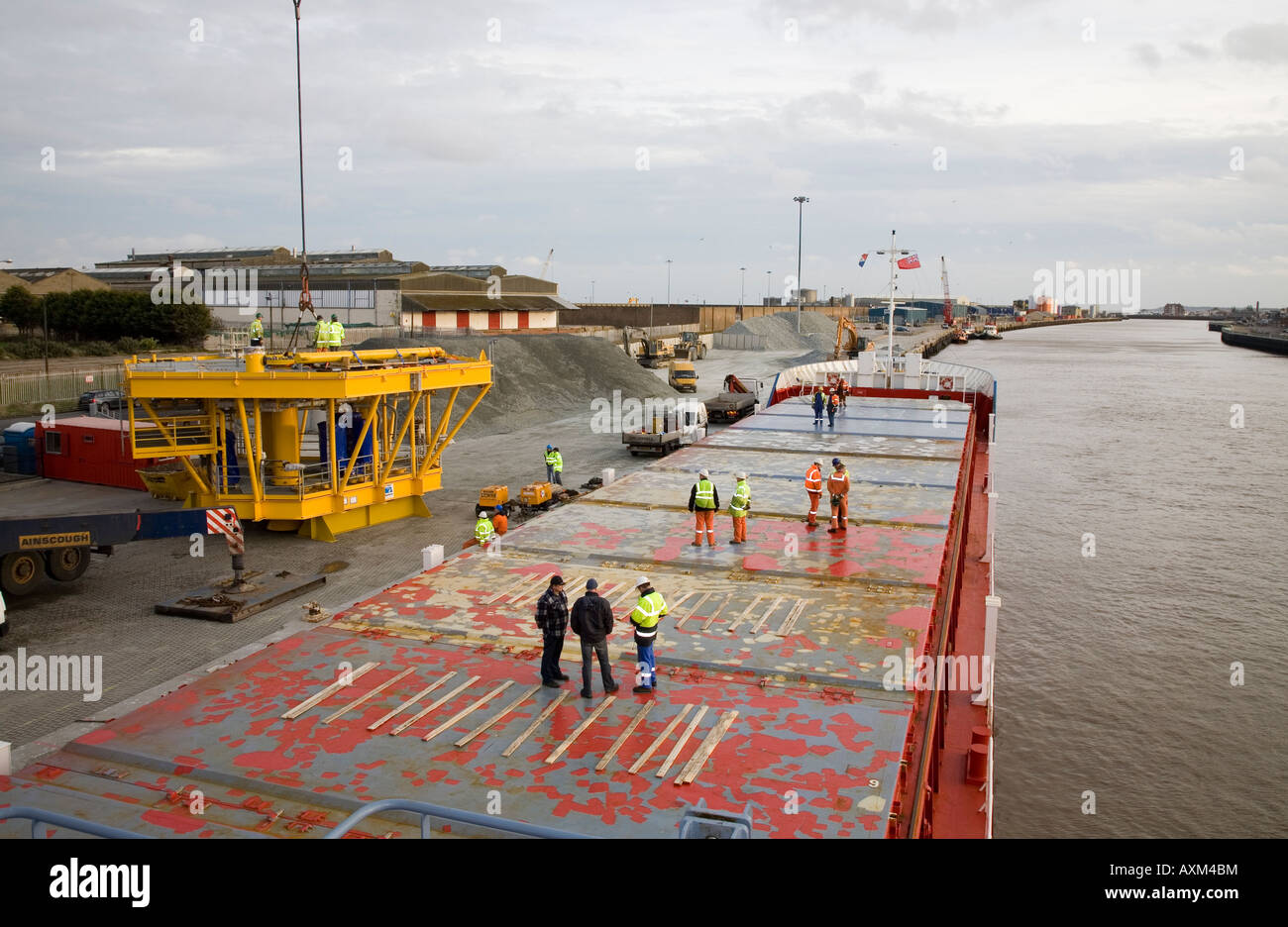Loading crew stand on deck on container ship as rig platform is lifted ...