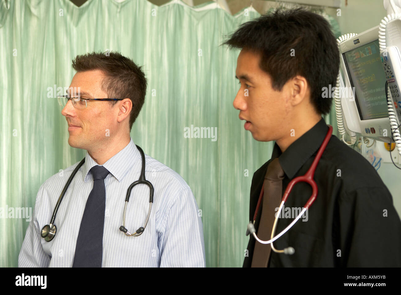 Two junior doctors talking on a hospital ward Stock Photo - Alamy