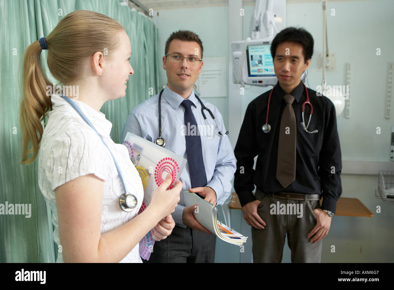 Three junior doctors talking on a hospital ward Stock Photo - Alamy