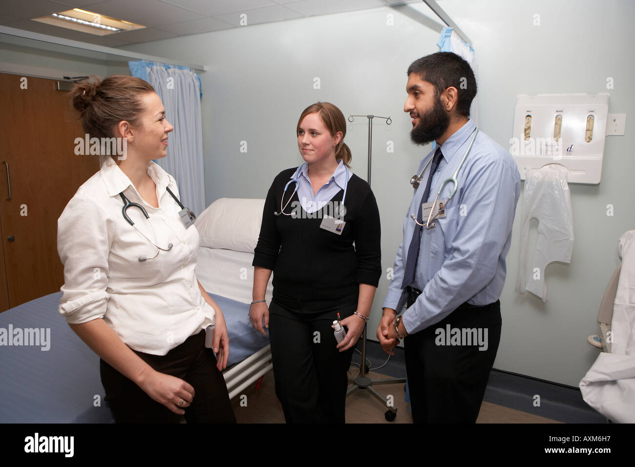 Three junior doctors talking on a hospital ward Stock Photo - Alamy