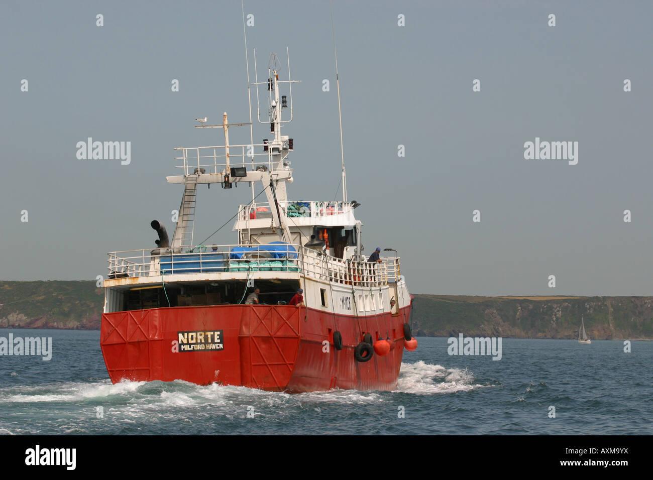 Red trawler boat at speed from rear Stock Photo - Alamy