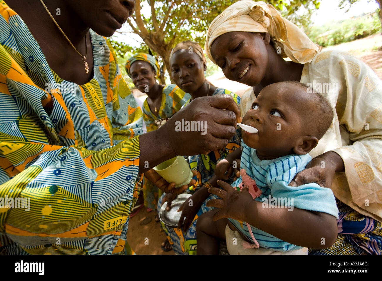 A woman gives a boy some of the oral re-hydration solution, Benin ...