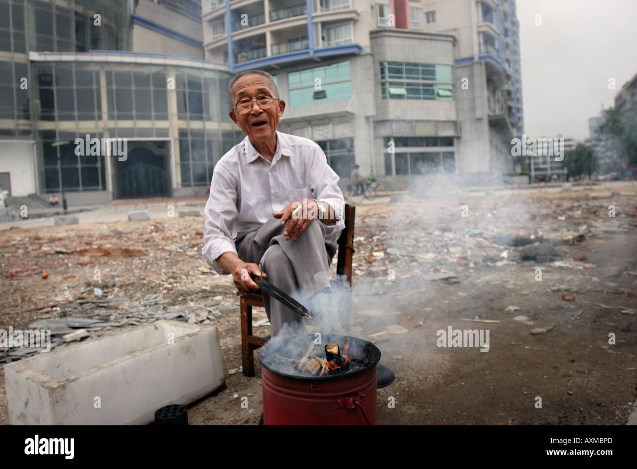 Elderly man cooking on an open fire, Shanghai, China Stock Photo - Alamy