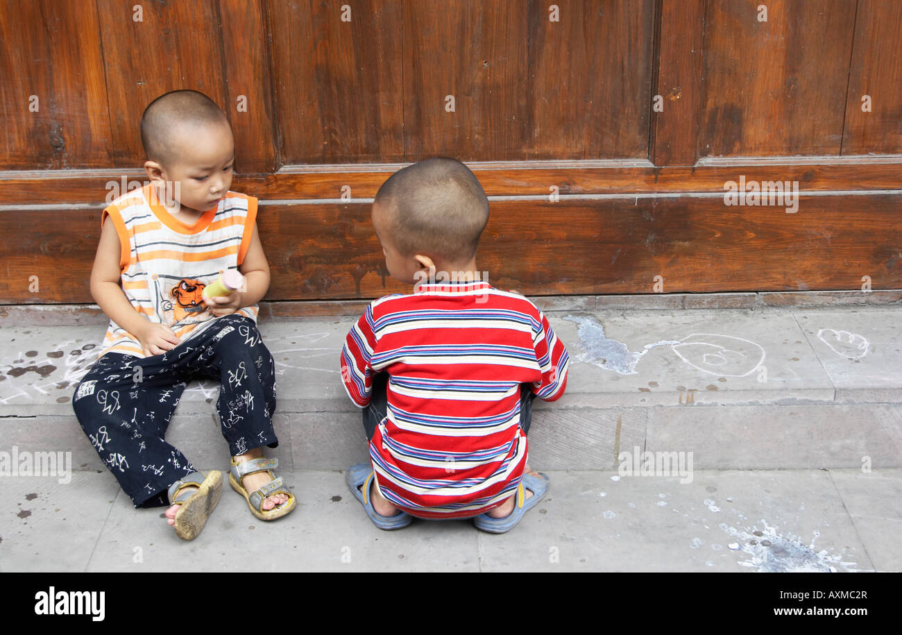 Two Young Chinese Boys Playing On Pavement Stock Photo - Alamy