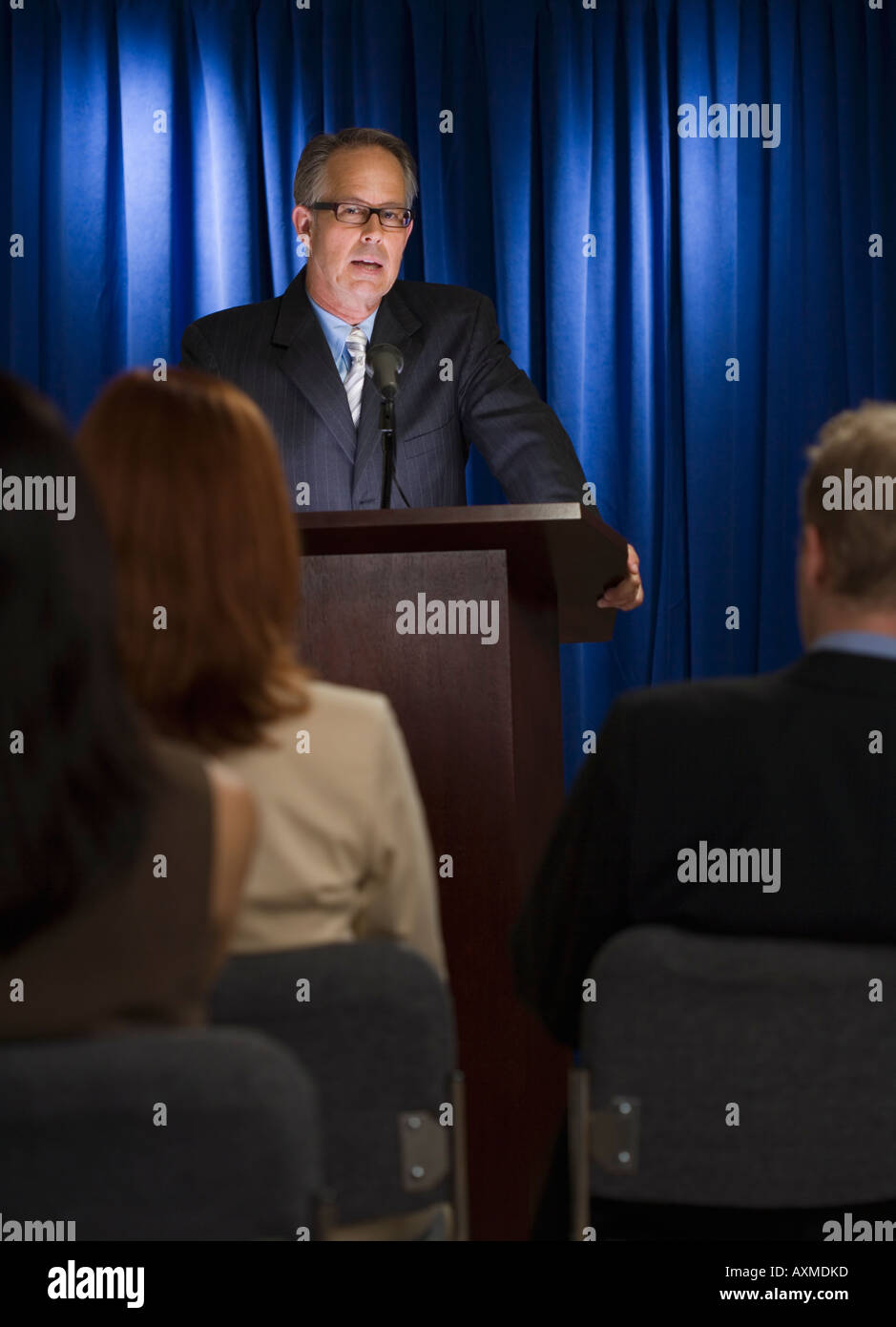 Businessman speaking at podium Stock Photo - Alamy