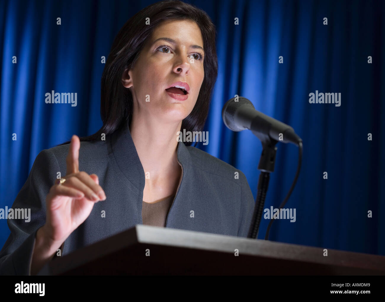 Close up of businesswoman speaking at podium Stock Photo - Alamy