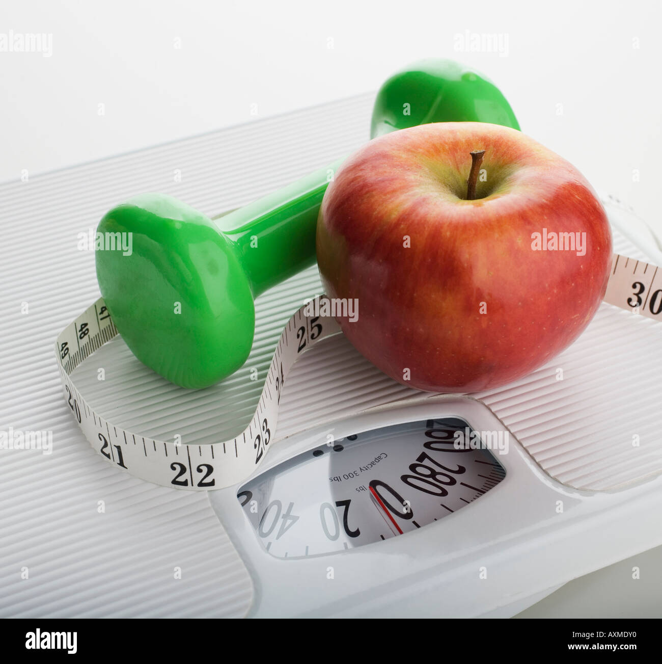 Studio shot of apple scale tape measure and dumbbell Stock Photo - Alamy