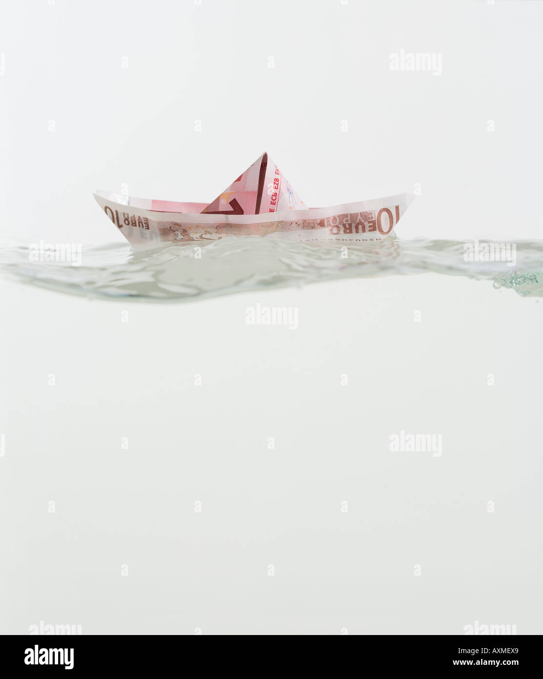 Boat made of paper money floating on water Stock Photo - Alamy
