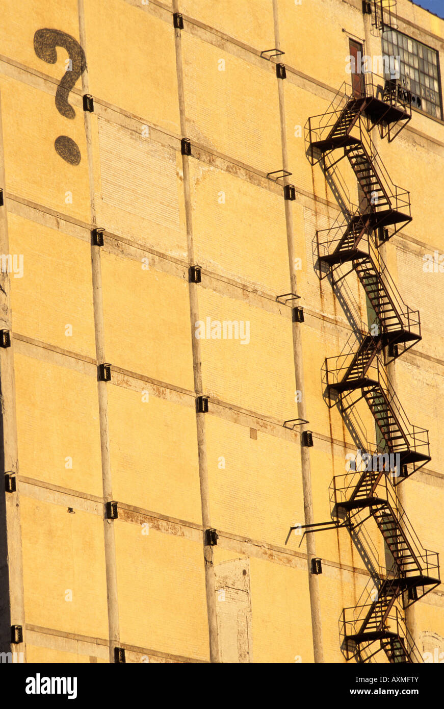 QUESTION MARK AND FIRE ESCAPE ON SIDE OF ABANDONED BUILDING IN ...