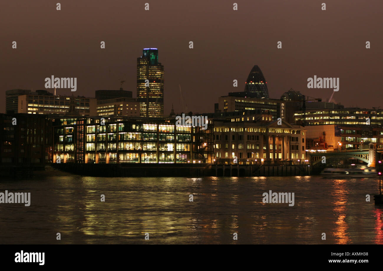 London Docklands at night with lights reflected on the Thames water ...
