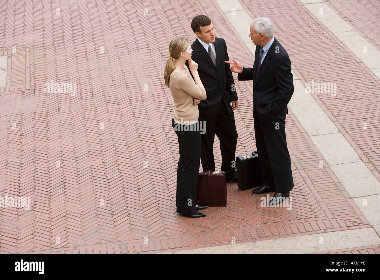 Three business people talking outdoors Stock Photo - Alamy