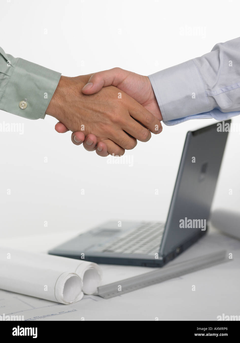 Two men shaking hands over laptop computer Stock Photo - Alamy