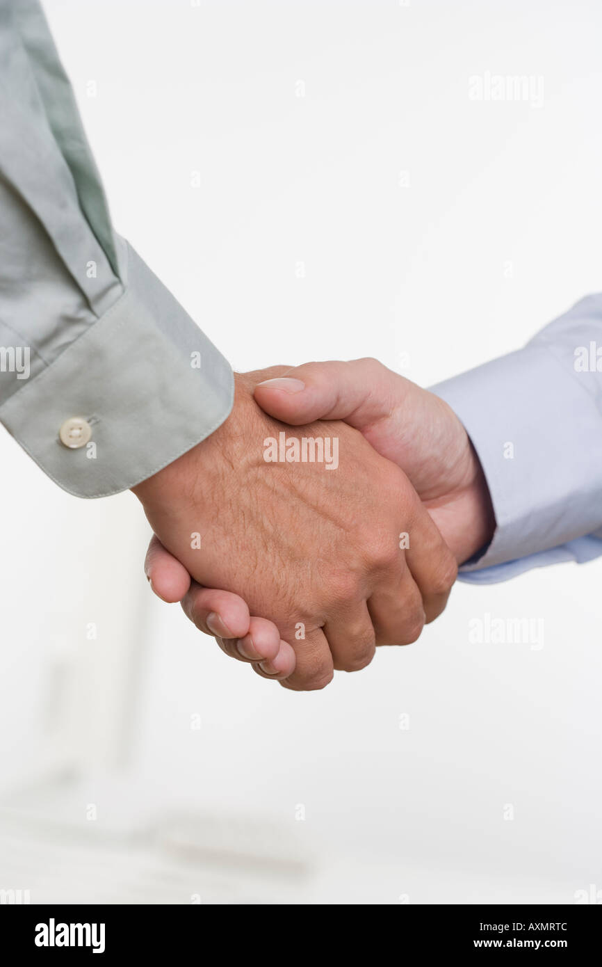 Men in shirtsleeves shaking hands Stock Photo - Alamy