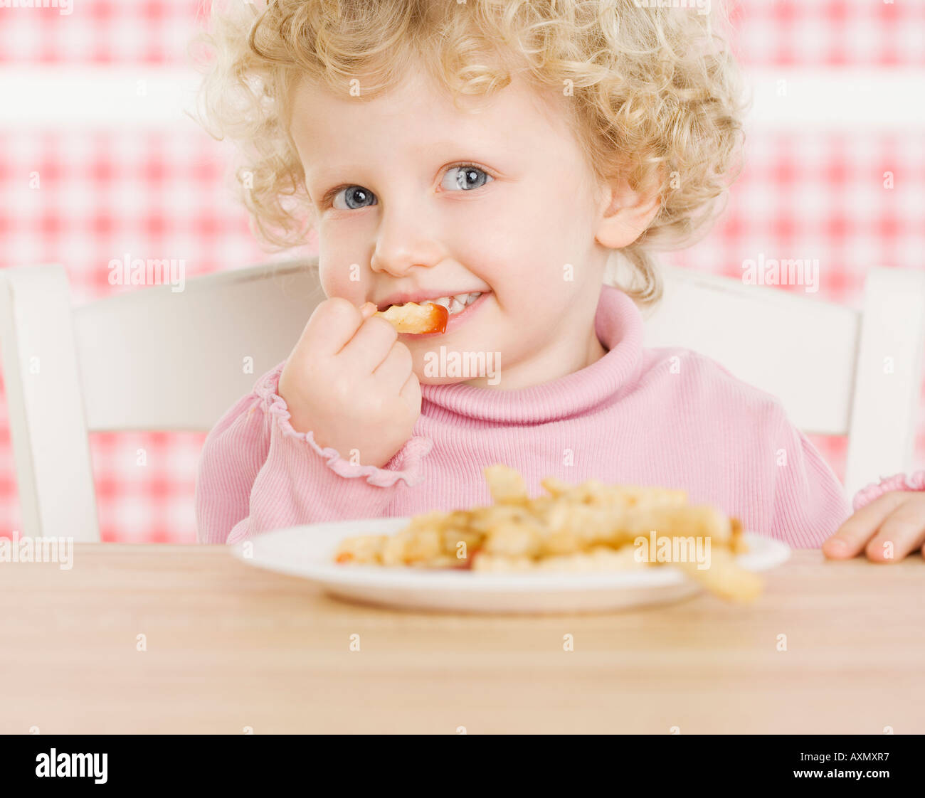 Female child eating French fries Stock Photo - Alamy