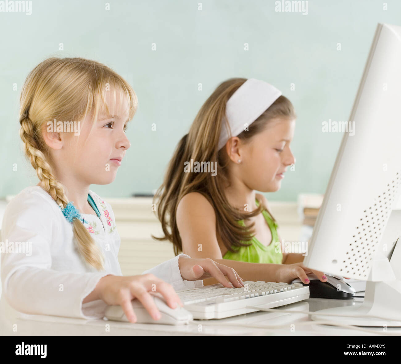 Two young girls using computers Stock Photo - Alamy
