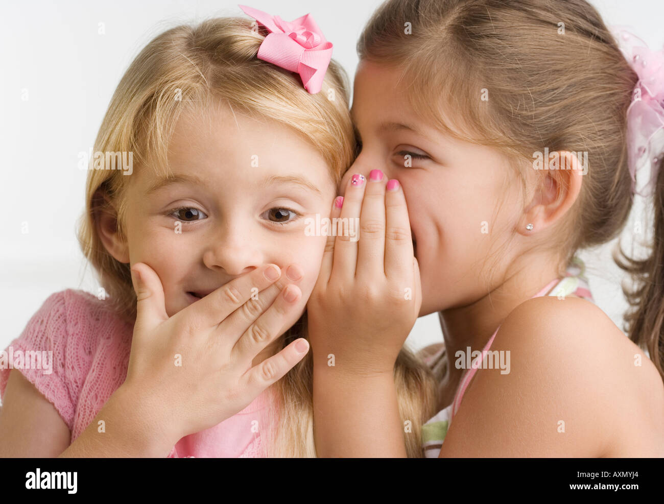 Young girl telling sister a secret Stock Photo - Alamy