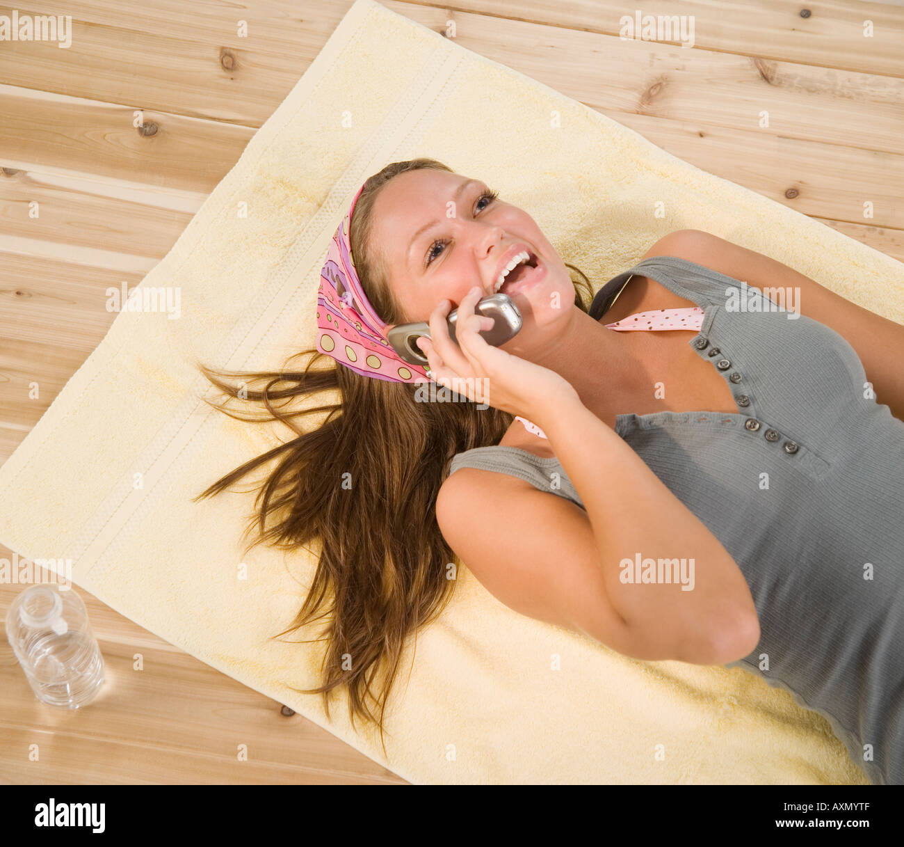 Young woman laying on floor using cell phone Stock Photo - Alamy