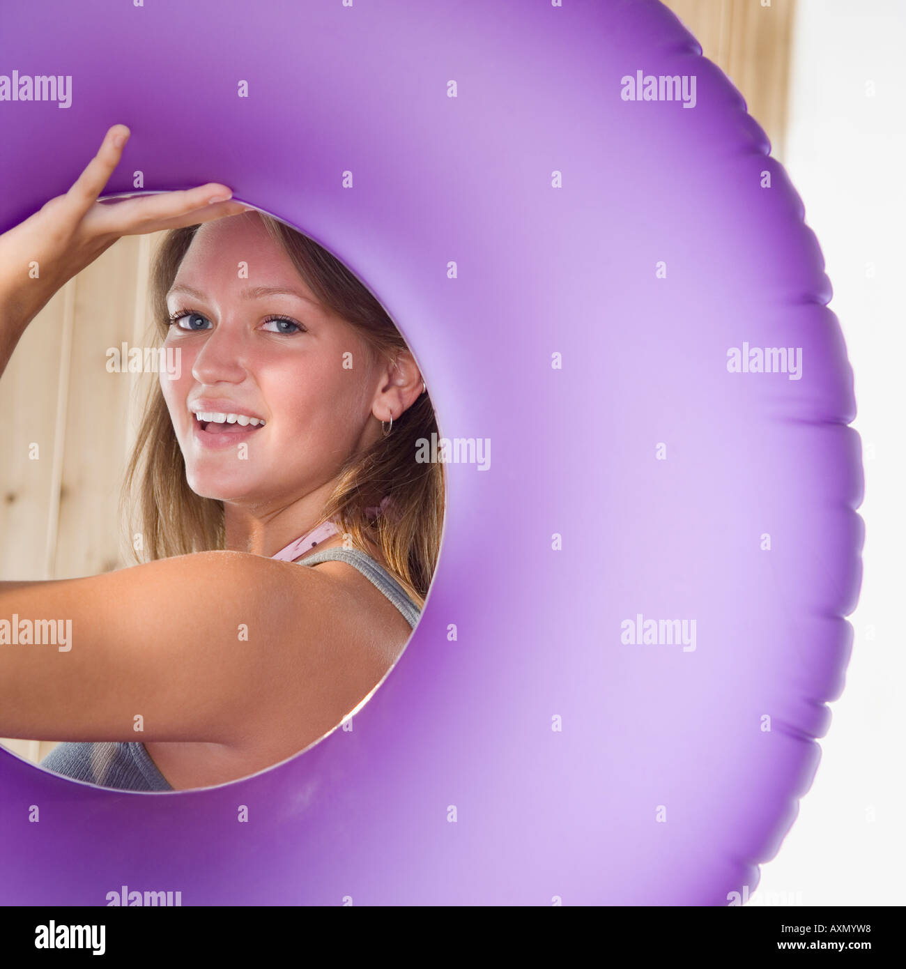 Young woman smiling through middle of inner tube Stock Photo - Alamy