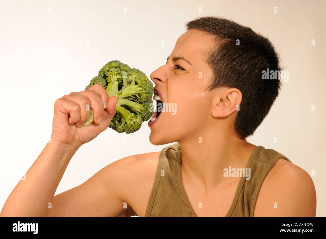 Studio portrait of woman eating broccoli Stock Photo - Alamy