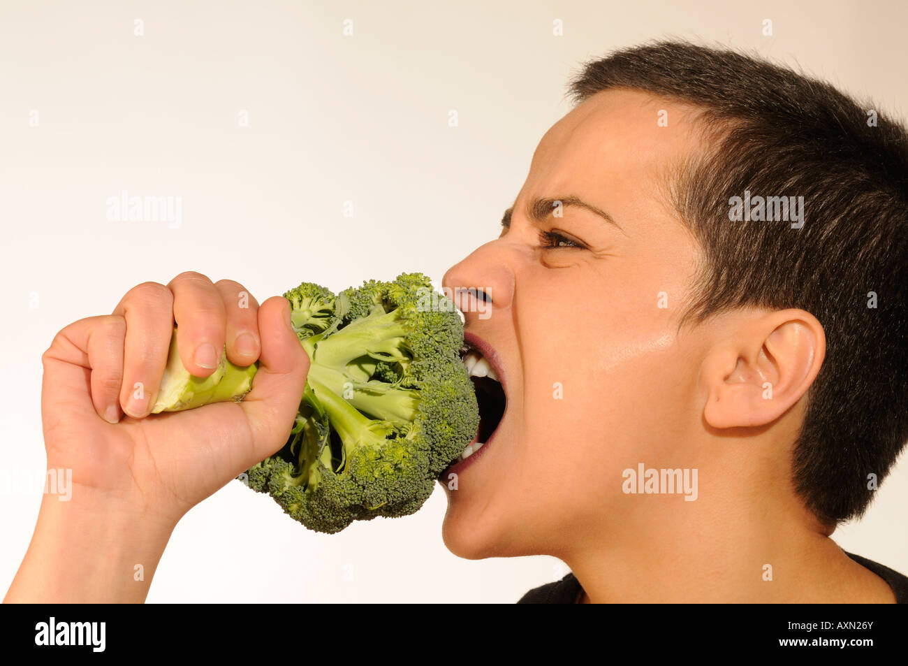Studio portrait of woman eating broccoli Stock Photo - Alamy
