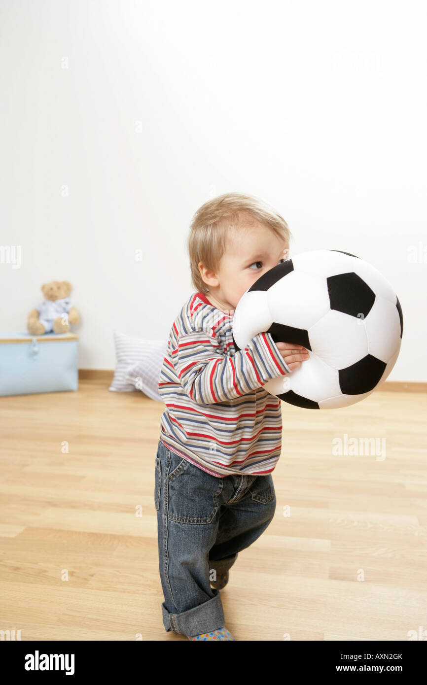 Baby boy holding a football Stock Photo - Alamy
