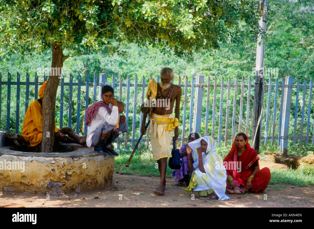 Indians sitting under a tree beside railway line on the Delhi to Agra ...