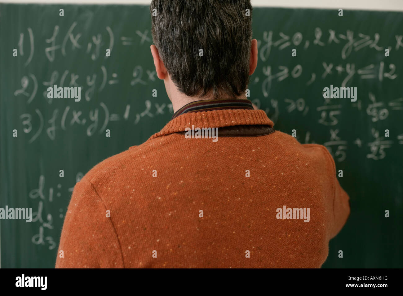 Teacher writing an arithmetic problem on blackboard Stock Photo - Alamy