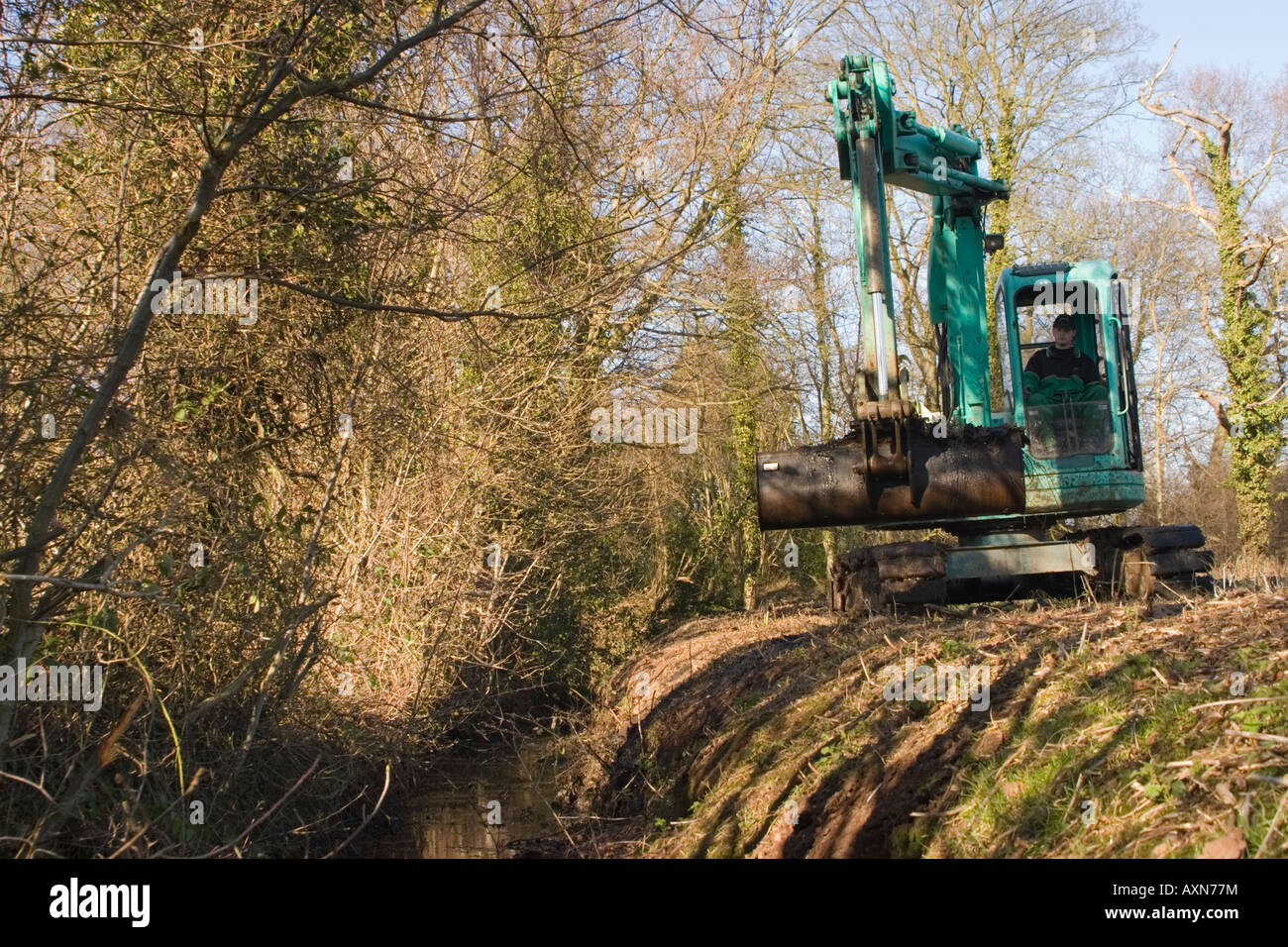 A catapillar tracked digger cleaning out a ditch Stock Photo - Alamy