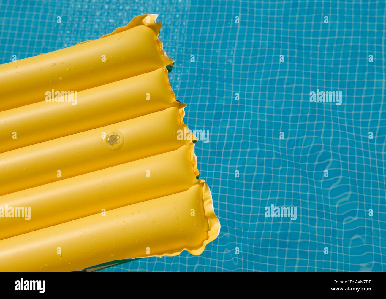 yellow inflatable lilo on swimming pool Stock Photo - Alamy