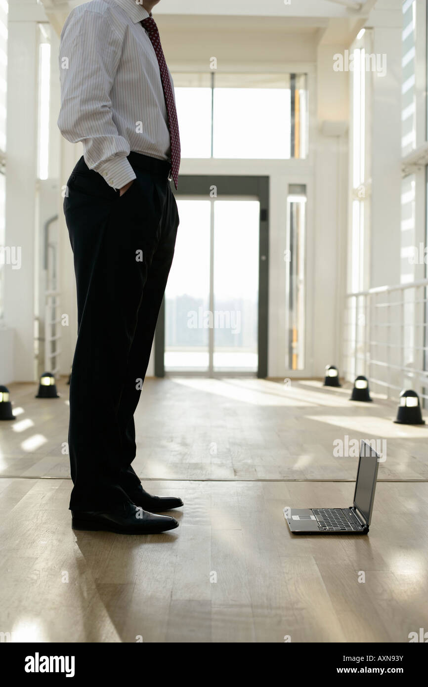 Laptop laying on a floor next to the legs of a businessman Stock Photo ...