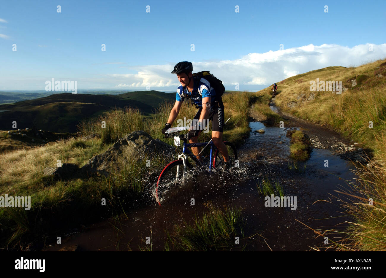 Mountain bike rider splashing through water on trail Stock Photo - Alamy