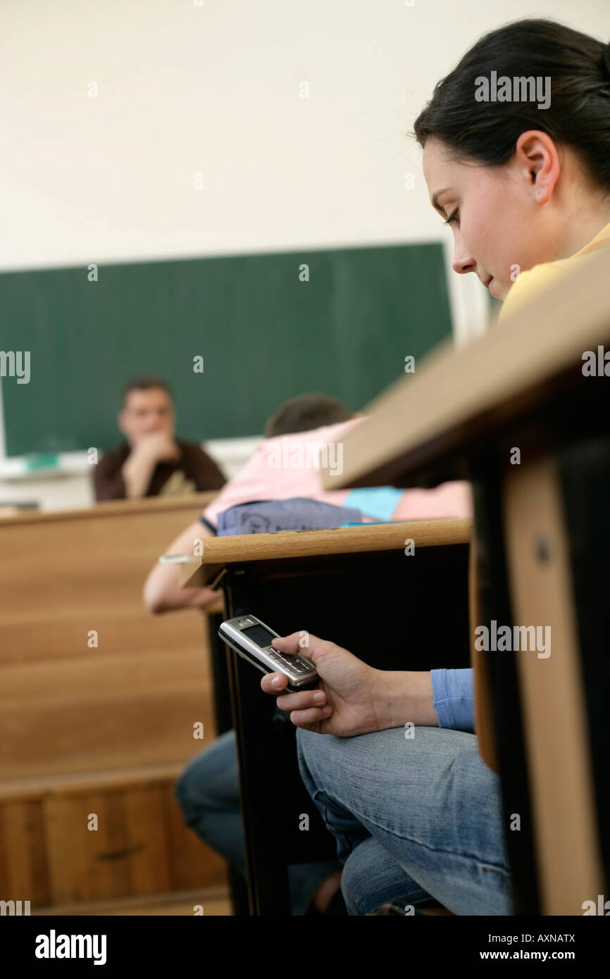 Teenage girl using a mobile phone under a table Stock Photo - Alamy