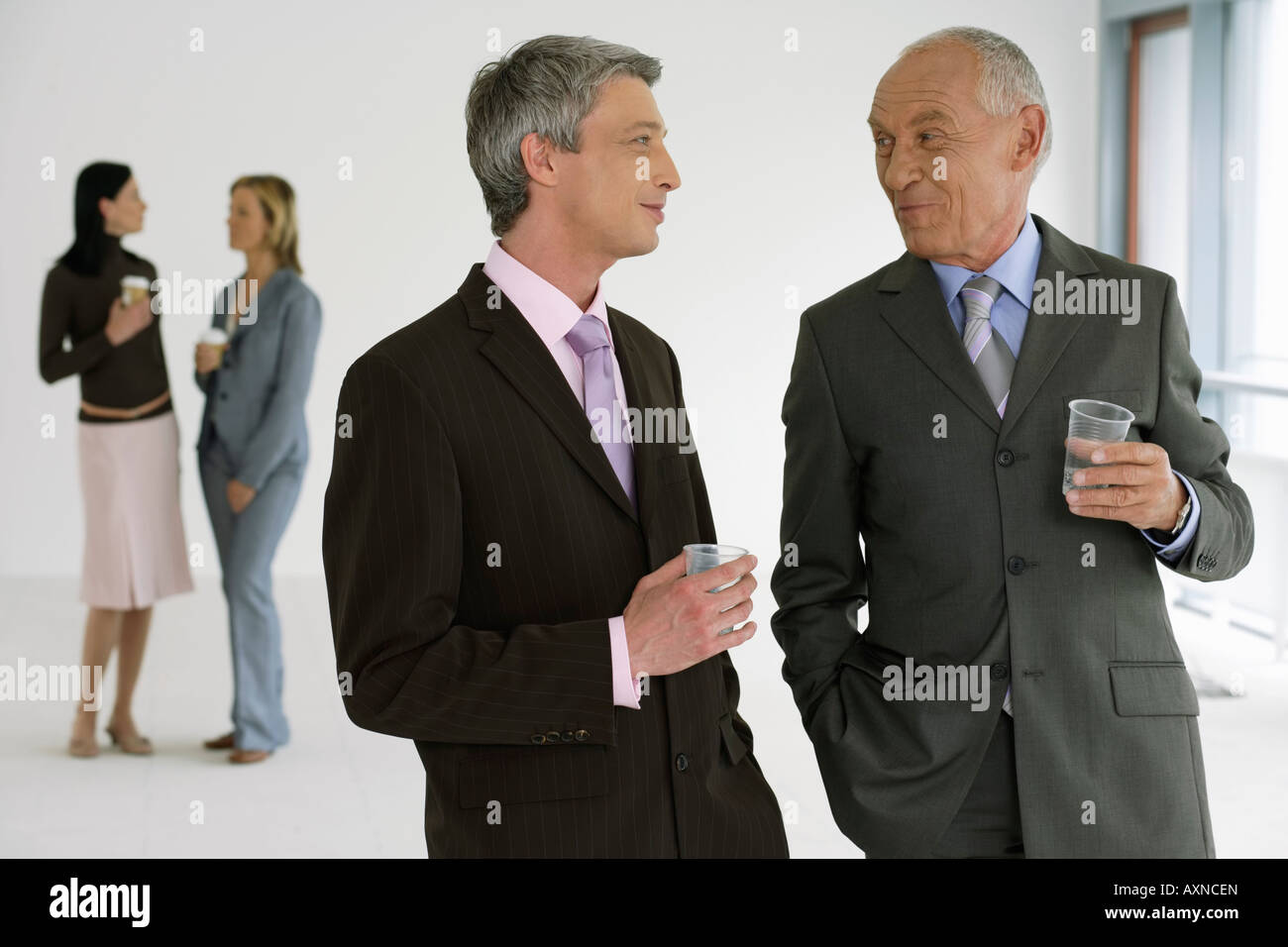 Two managers with glasses in their hands in high spirits, two business ...