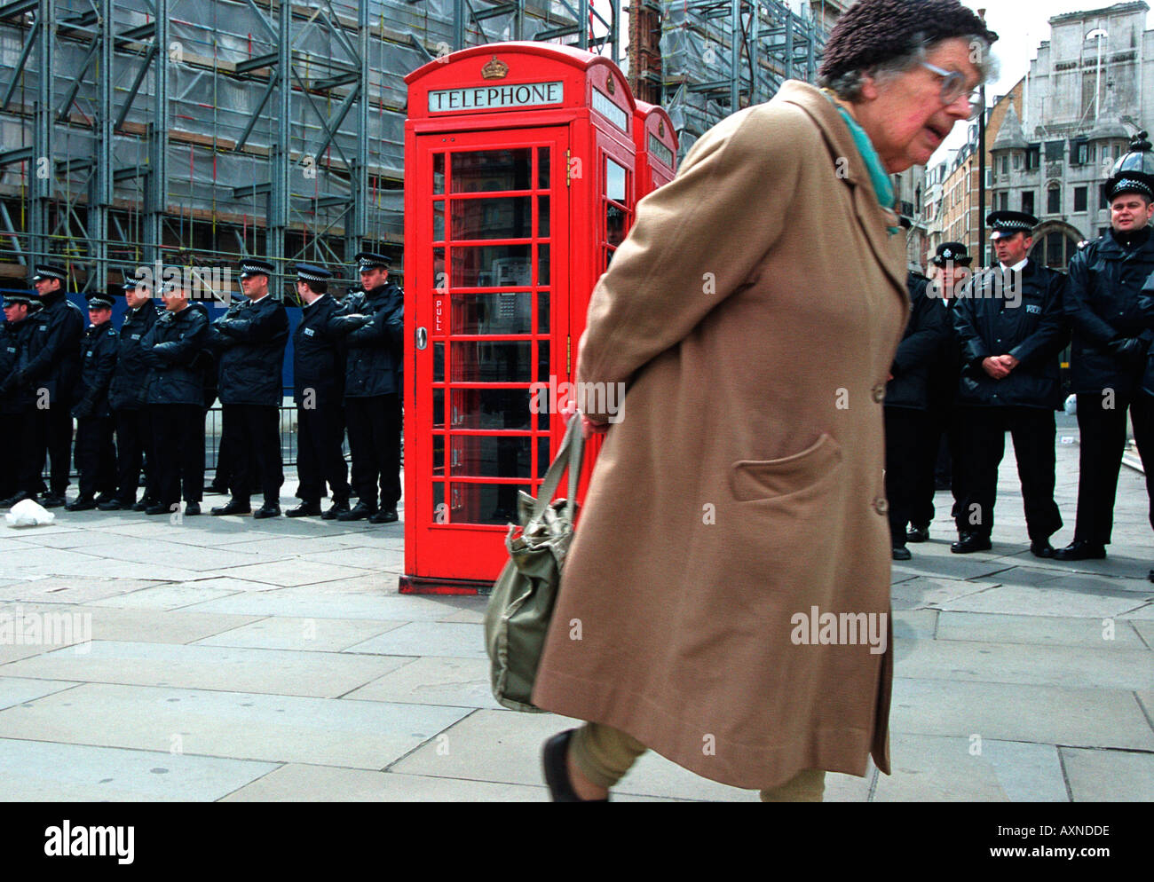 Elderly woman walking past riot police line during Mayday anti ...