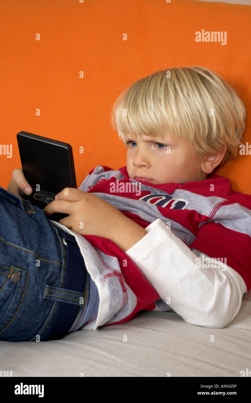 Boy (4-5 Years) playing hand held computer game Stock Photo - Alamy