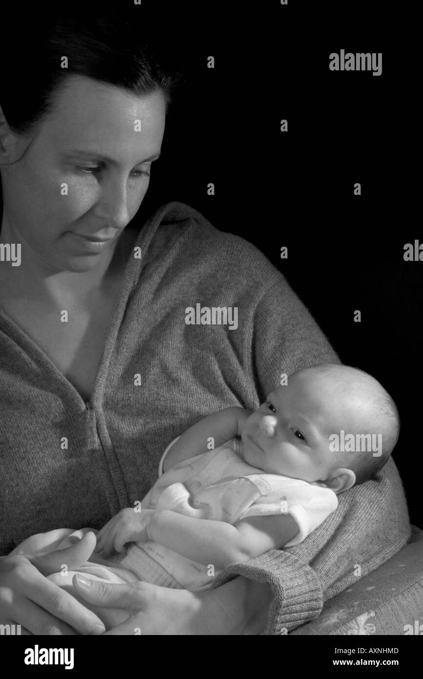 Contented Baby Resting In Mothers Arms Stock Photo - Alamy