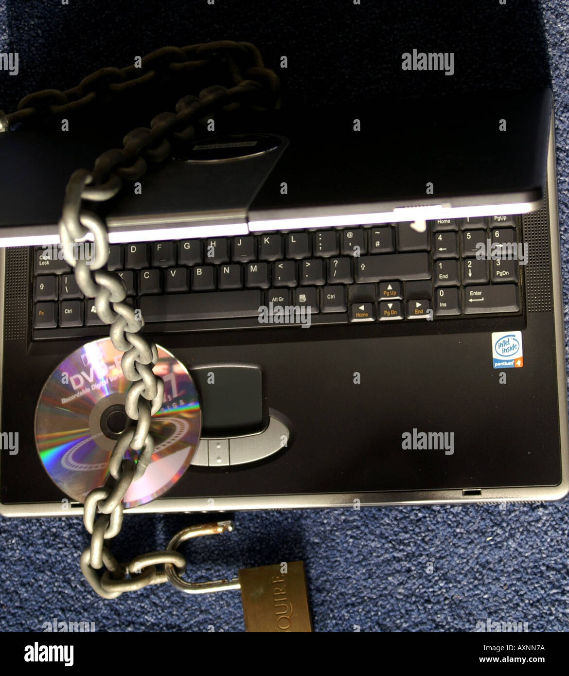 Laptop keyboard with chain padlock and DVD disc Stock Photo - Alamy