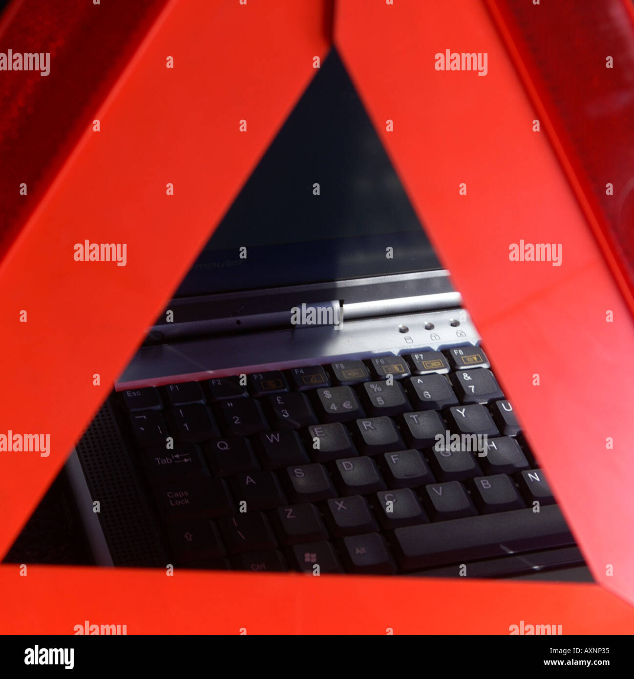 Laptop keyboard through a hazard warning triangle Stock Photo - Alamy