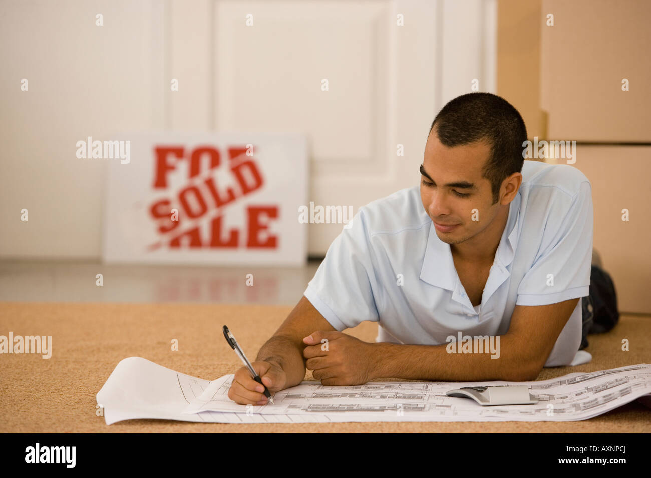 Man writing on blueprints in new house Stock Photo - Alamy