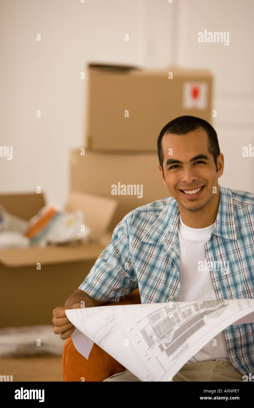 Young man looking at blueprints in new house Stock Photo - Alamy