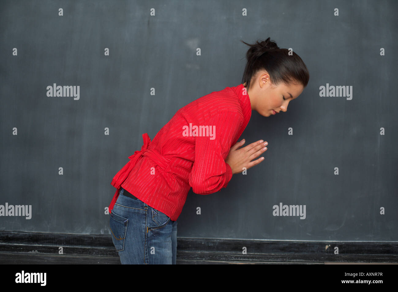 Asian woman bowing in front of a blackboard Stock Photo - Alamy