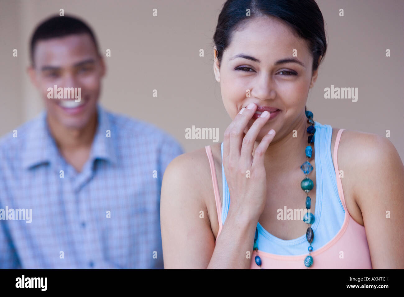 Young woman laughing with boyfriend in background Stock Photo - Alamy