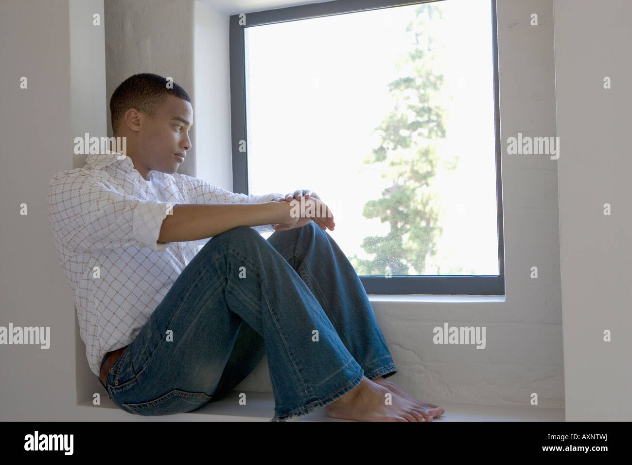 African man sitting in window Stock Photo - Alamy
