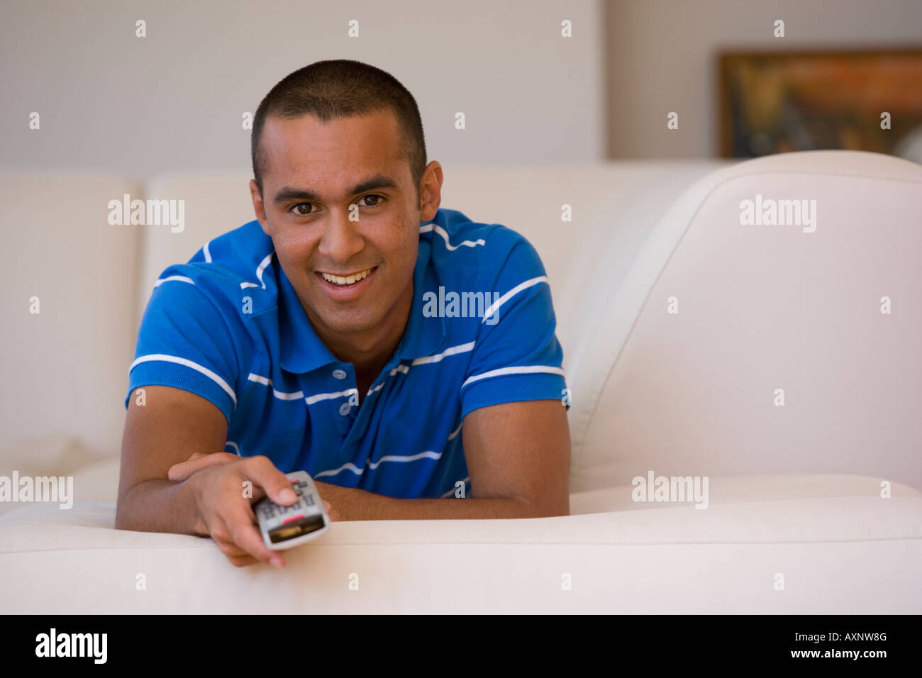 Young man pointing remote control Stock Photo - Alamy