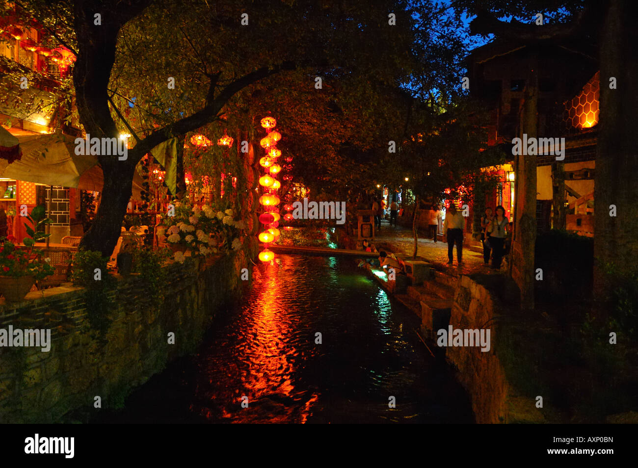 Lijiang at night. Red lanterns decorate the shops along the street and ...