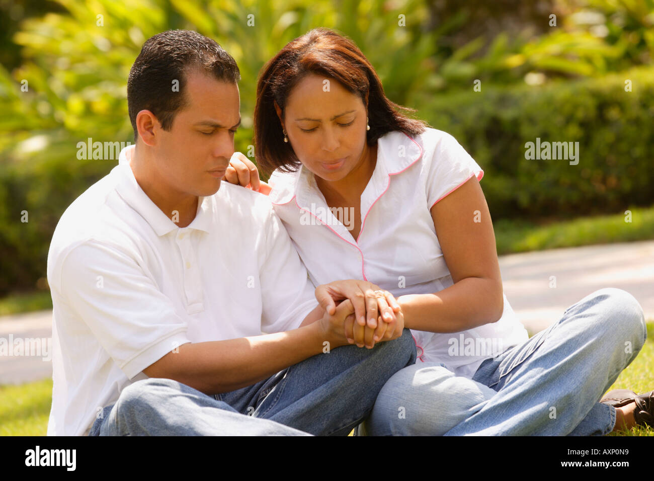 Couple praying together Stock Photo - Alamy