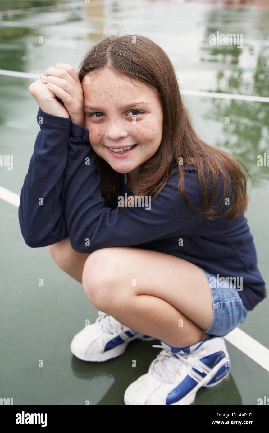 Girl crouching on playground Stock Photo - Alamy