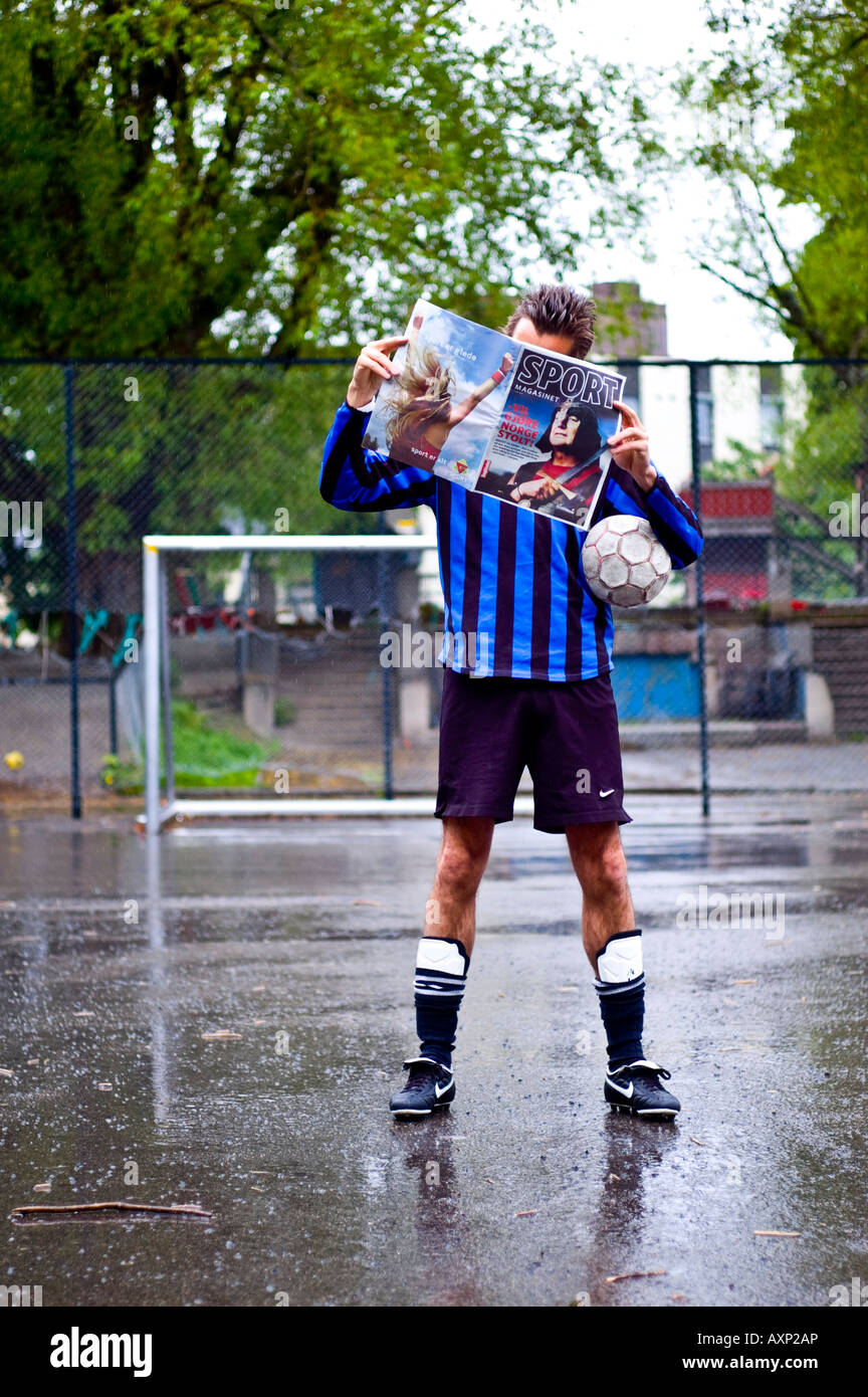 Footballer reading a newspaper Stock Photo - Alamy