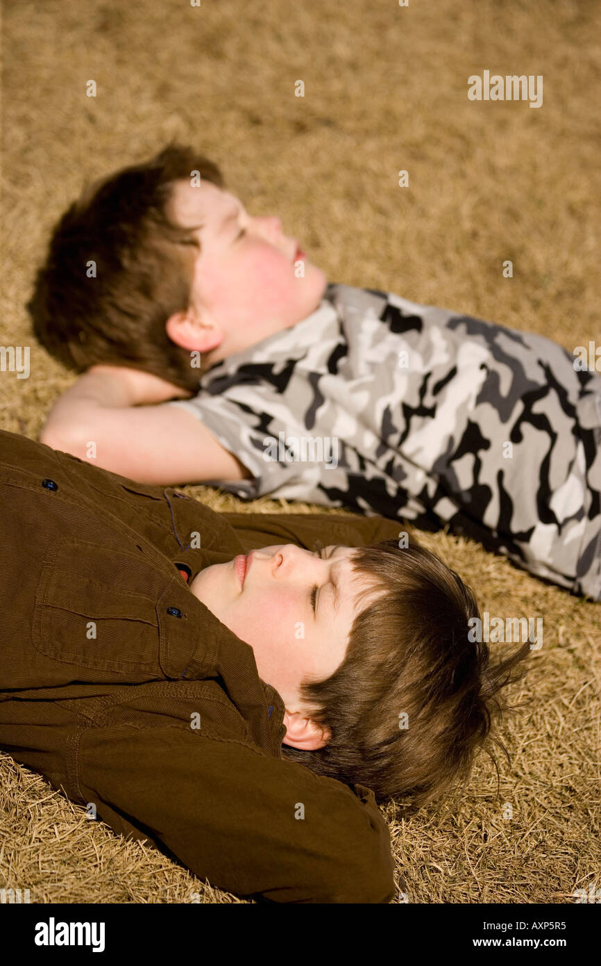 Boys laying on the ground Stock Photo - Alamy