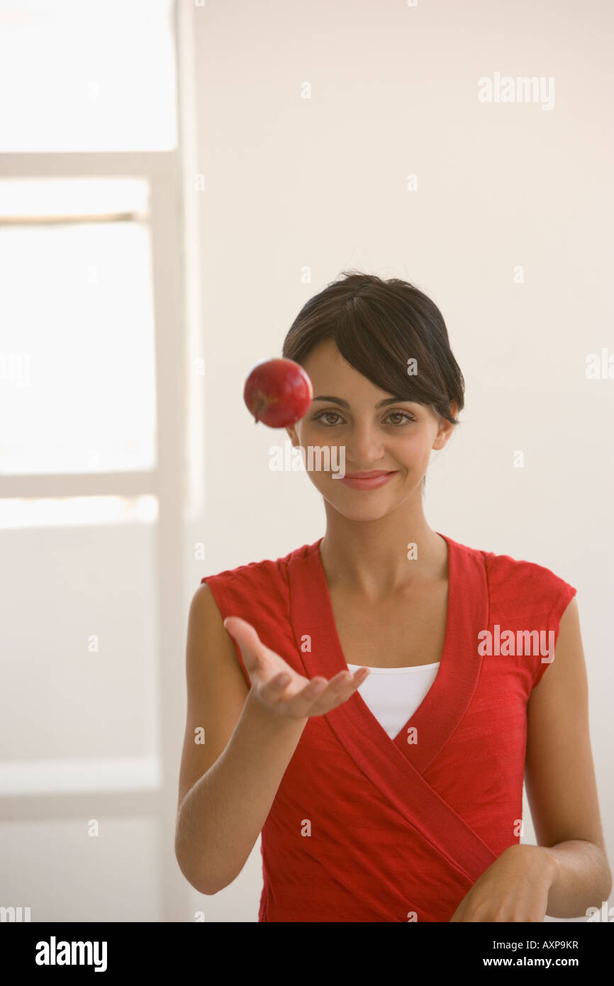 Young woman throwing apple in air Stock Photo - Alamy